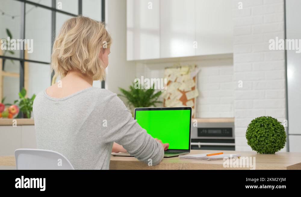 Girl uses green screen chroma key laptop for learning, writes down ...