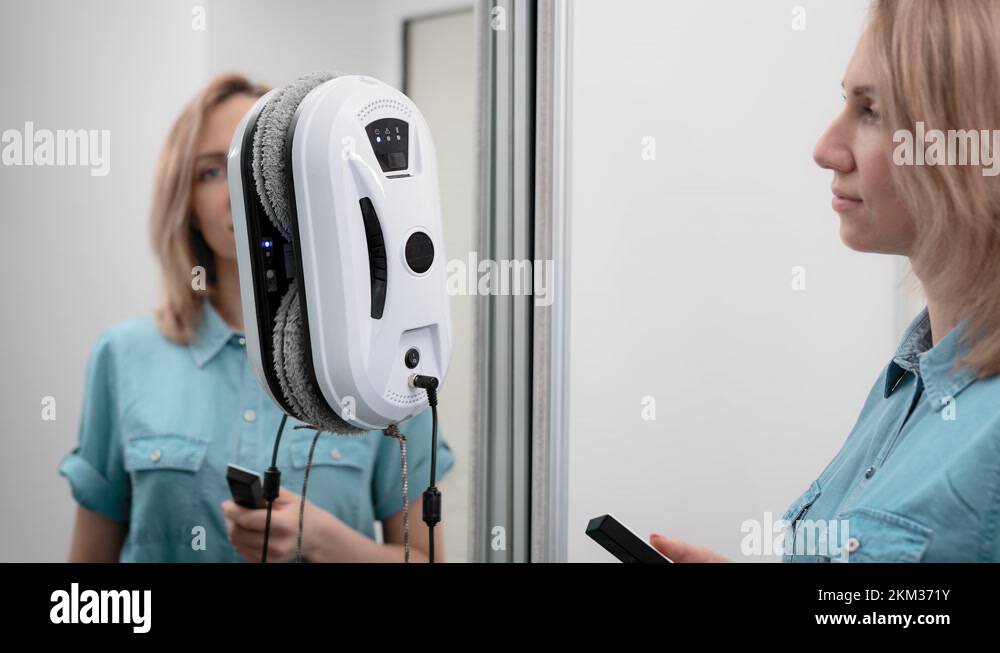 Cleaning robot at work at home. The robot cleans the mirror in the ...