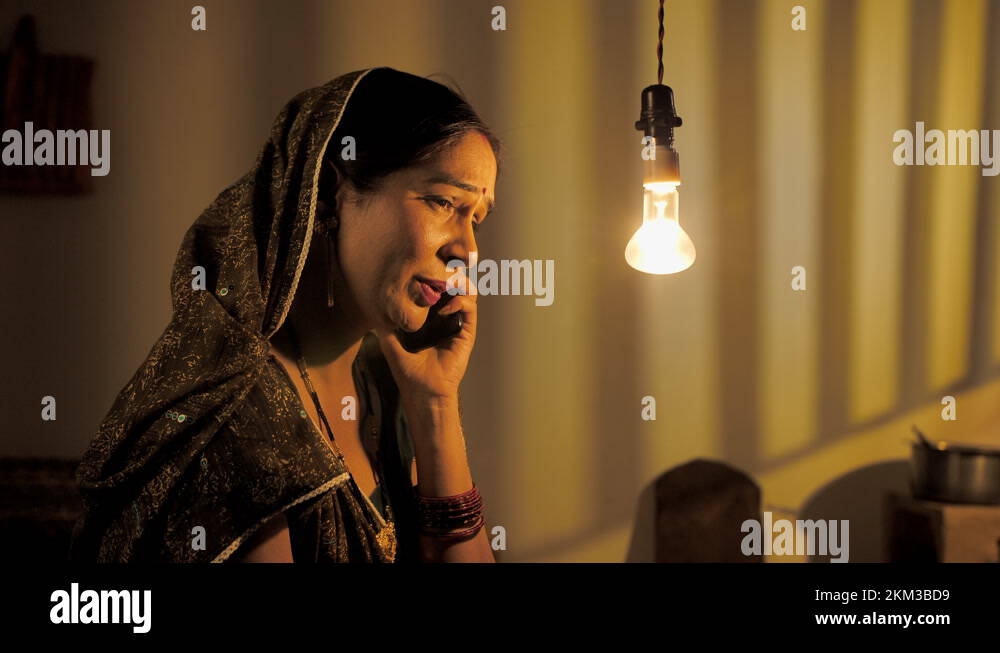 An attractive villager talking on her mobile at home - Independent ...