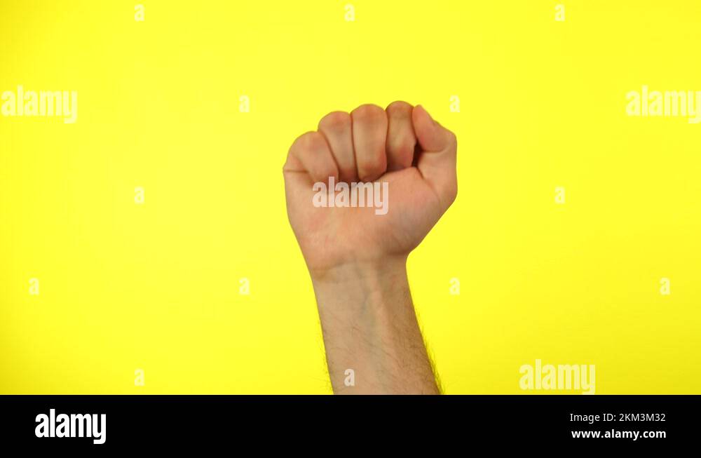 Male hand knock knock knocking on camera, isolated on yellow studio ...