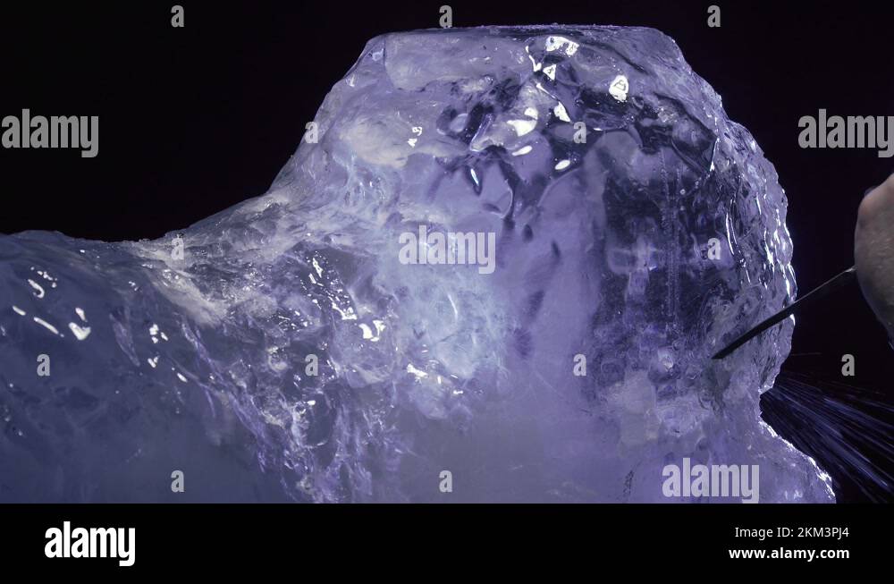 Shaping of an ice sculpture by a professional artist with a chisel and ...