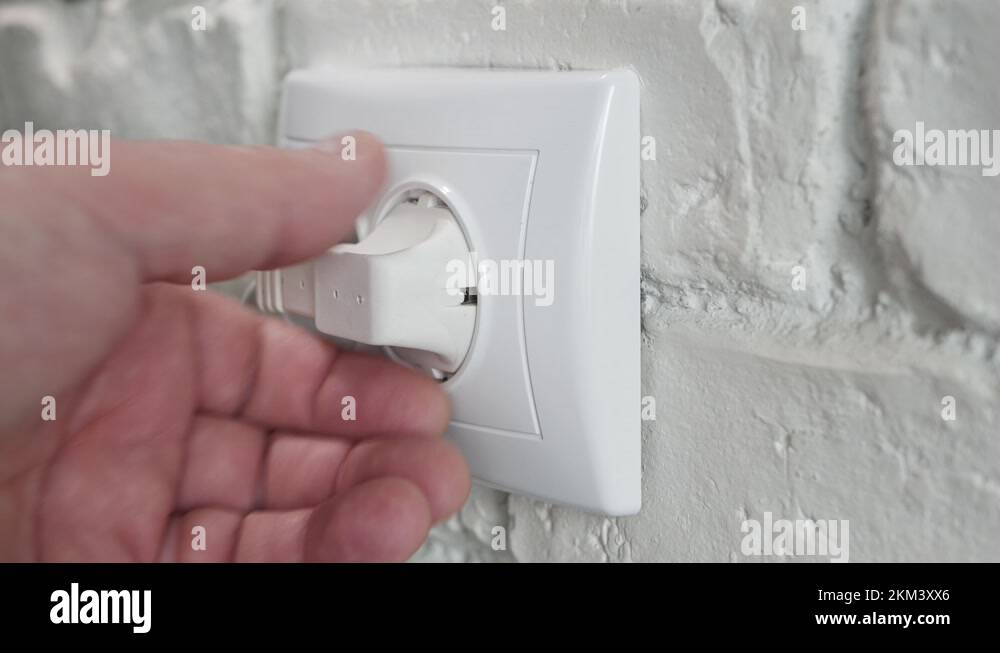 Unplugging an Electrical Power Cord from a Wall Socket in the Office ...