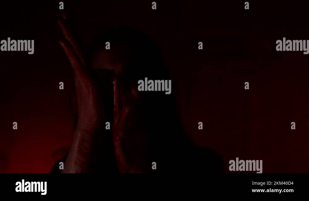 vampire woman with black eyes is licking blood from her arms, possessed ...