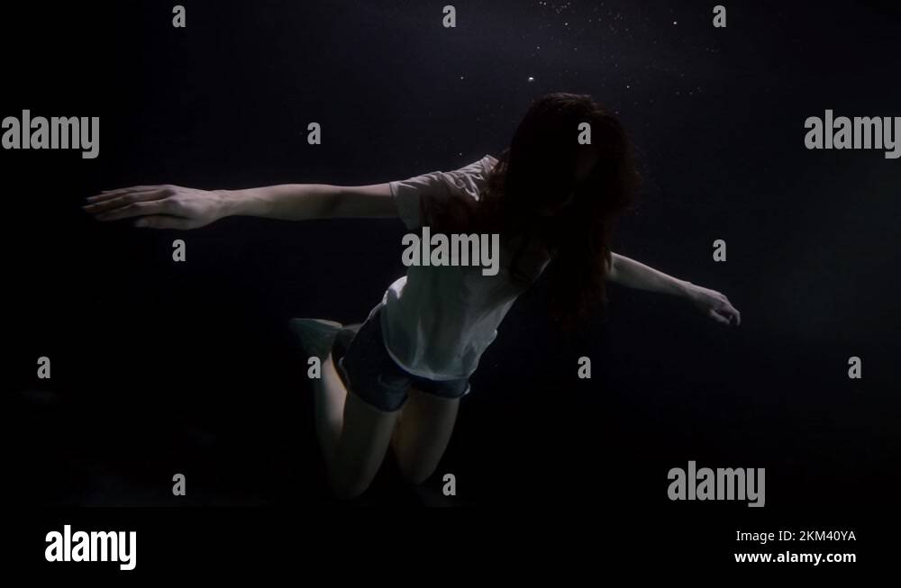 motionless body of adult woman is floating underwater, female figure in ...