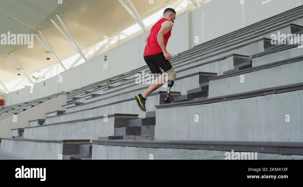 Caucasian disabled male athlete with prosthetic leg training, running ...