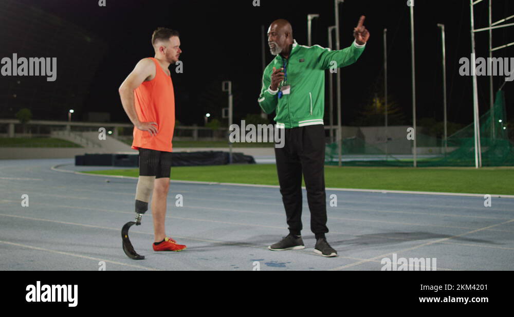 Diverse male coach and disabled male athlete with running blade ...