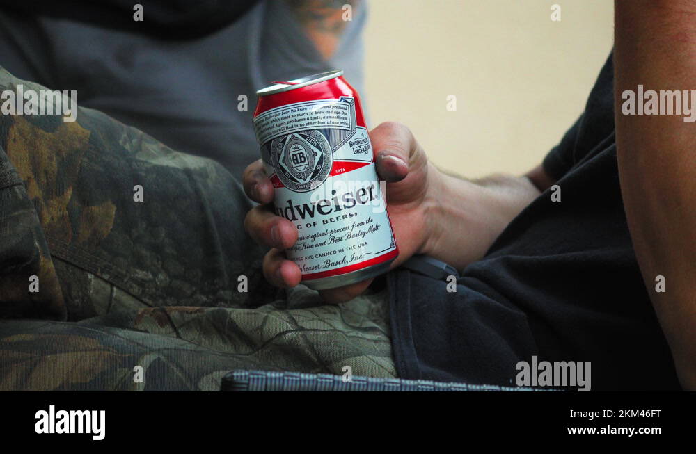 Man relaxing with a Budweiser beer in hand. Close up static shot Stock ...