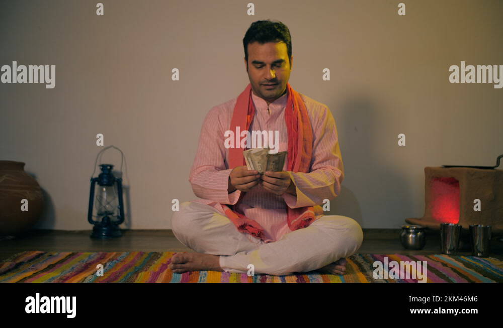 Middle-aged farmer counting his hard-earned money while sitting on the ...