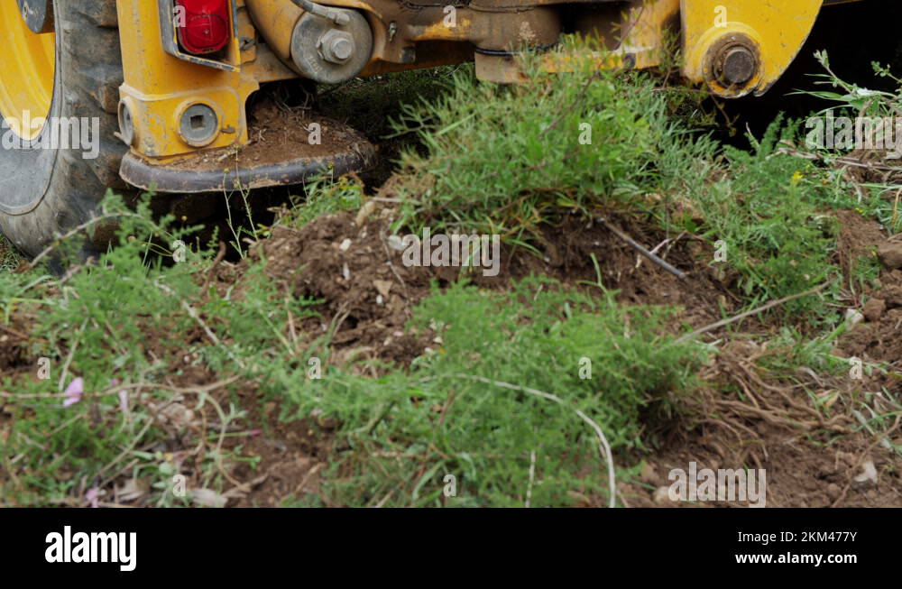 Backhoe operating in a Land on The Nature. Stabilizer Arm elevates and ...