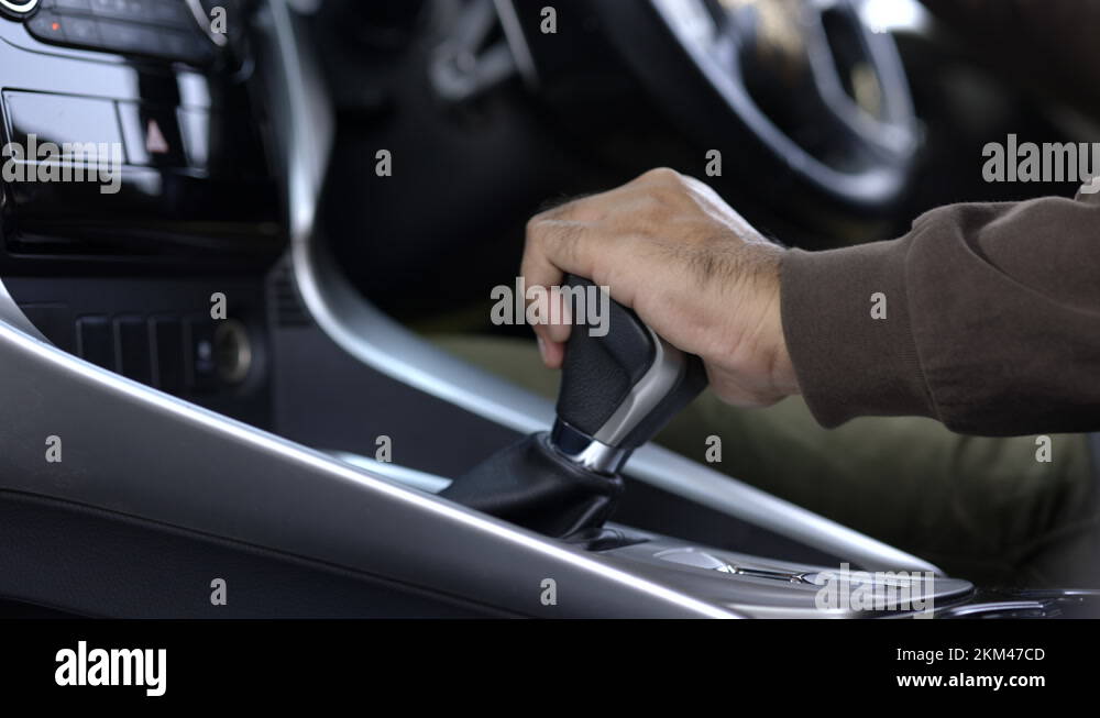 Young men getting new car and his hand control the stick shift ...