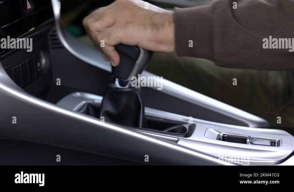 Young men getting new car and his hand control the stick shift ...