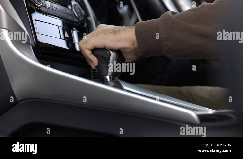 Young men getting new car and his hand control the stick shift ...
