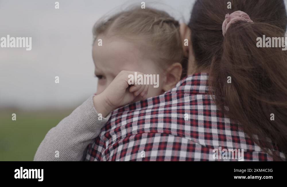Mommy soothes baby. child is crying in park in arms of mom. family ...