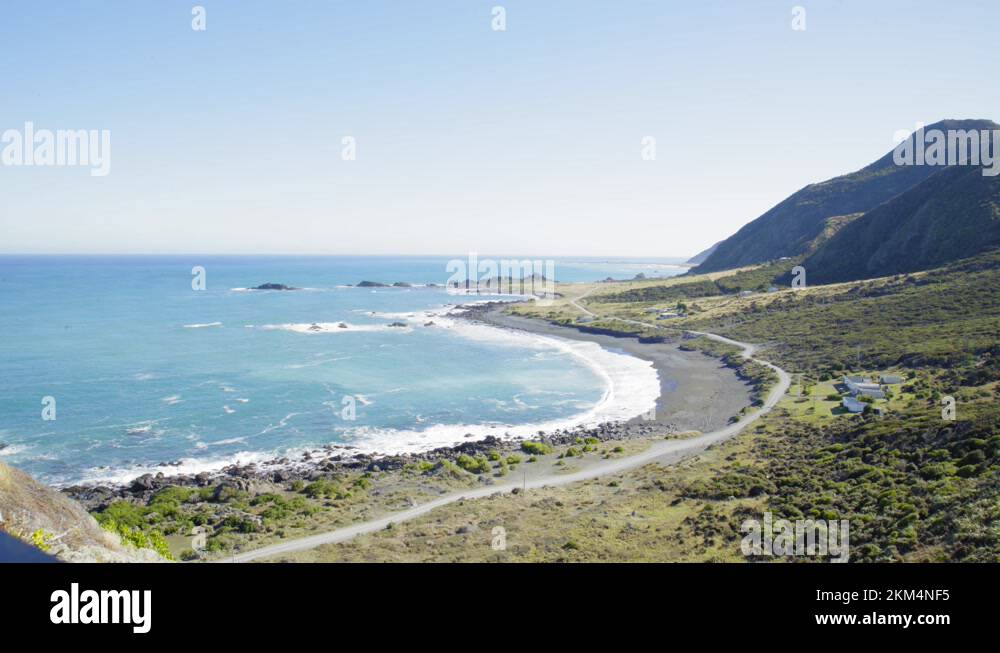 Walking towards a fence to look out over a cliff towards a beach and ...