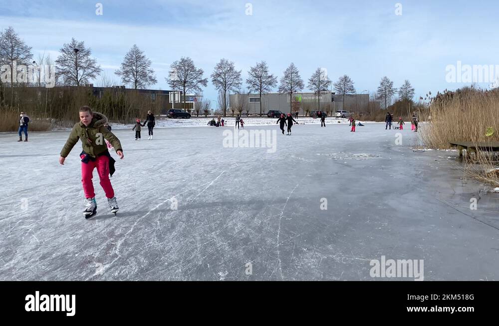 People enjoy ice skating, sledding and ice walking on a frozen pond in ...