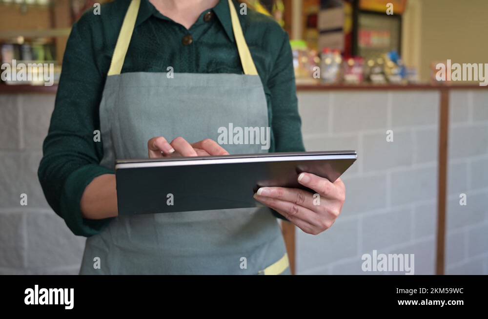 female waiter takes an order from a customer using a tablet in a small ...