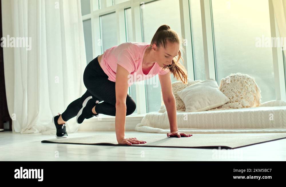 Young Woman Making Plank Spreading Legs Apart Exercise in Dynamic at ...
