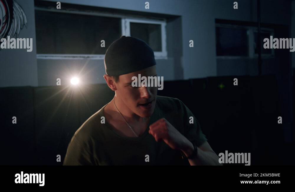 Alone boxer improves boxing movements in dark gym in slow motion. Young ...