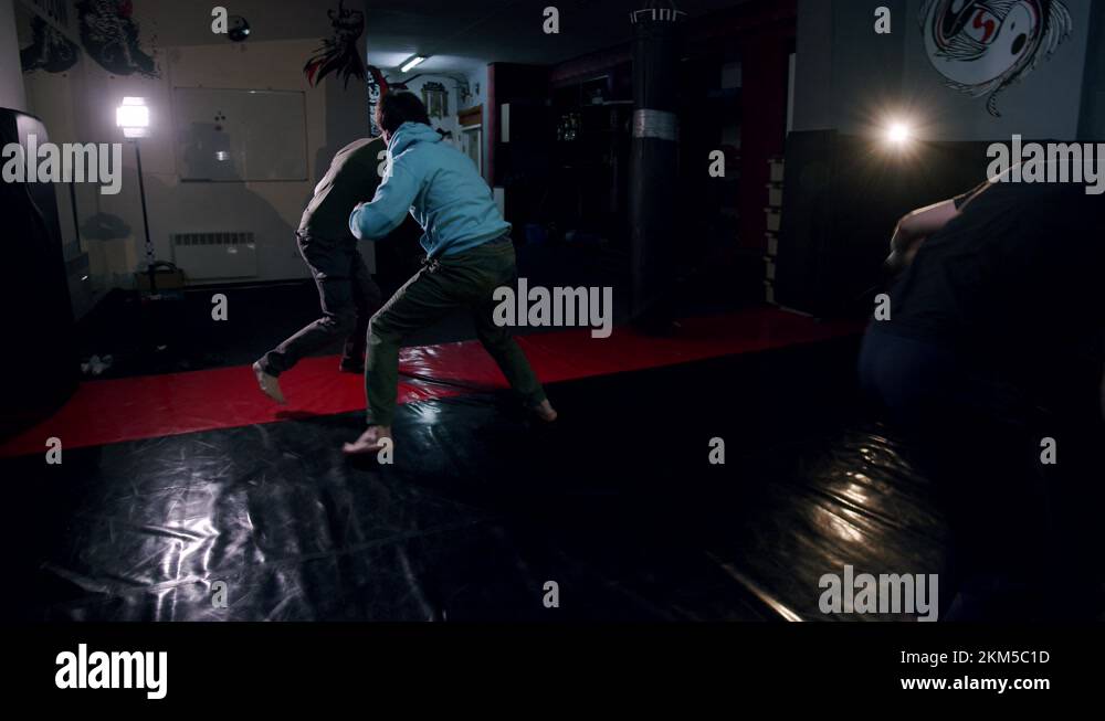 Fight scene of three male stunts on a gym. Men improve boxing movements ...