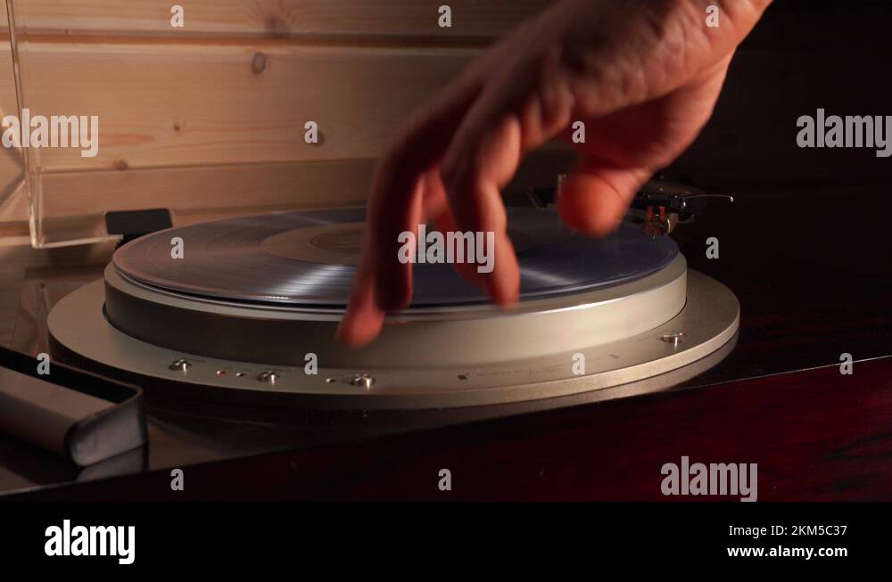 a man's hand presses a button, stopping the turntable and removes a ...