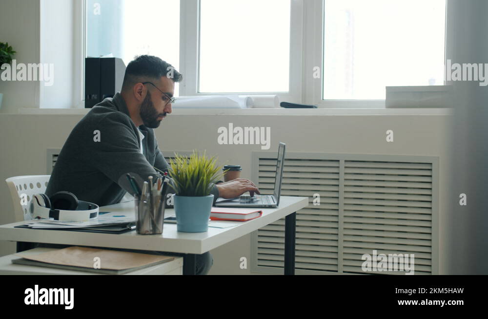 Mad office worker using laptop hitting table with fists and going away ...