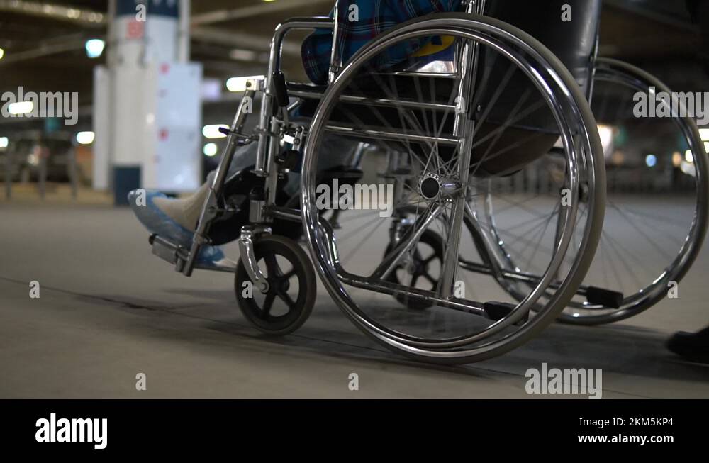 Wheelchair rides bottom view. A woman carries a disabled person in a ...