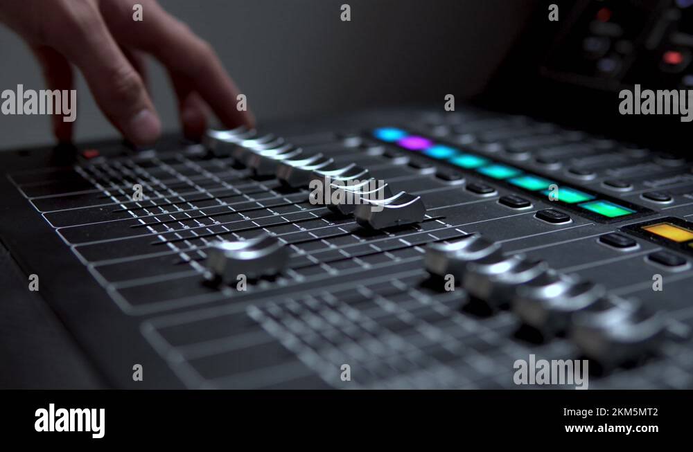 Man works on a professional electronic audio mixer. A control panel for ...