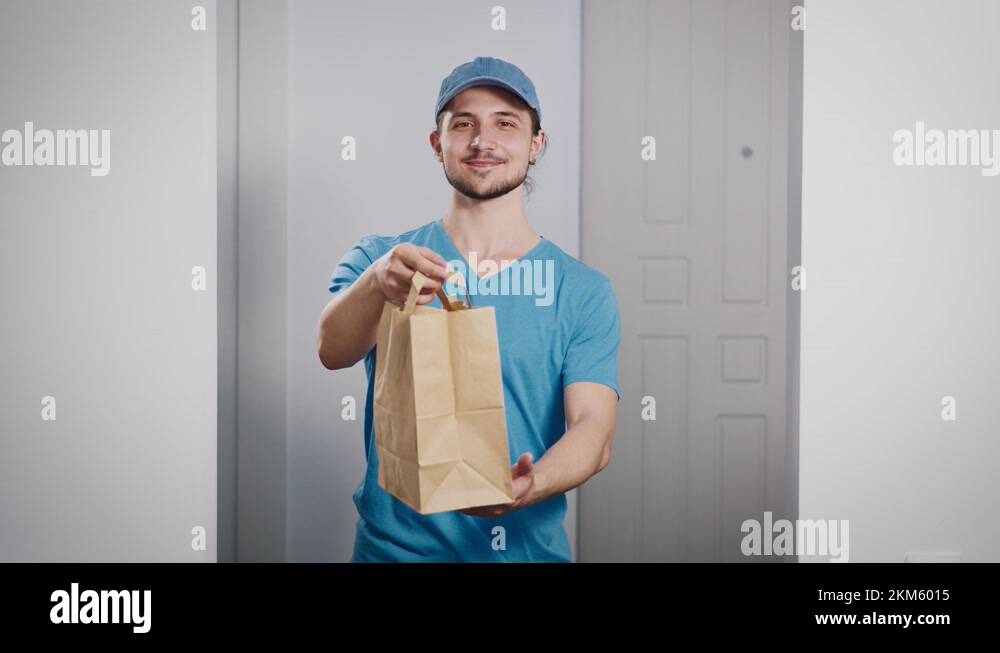 A food delivery man brought home an order from a restaurant. Handsome ...
