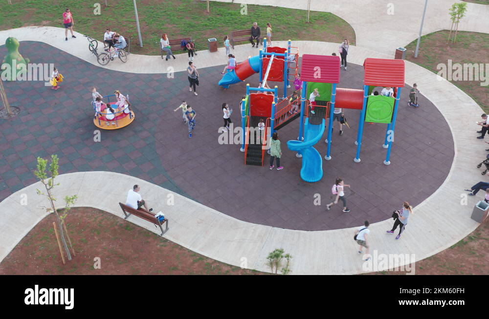 Playground for kids in a park, busy with excited and joyful children ...
