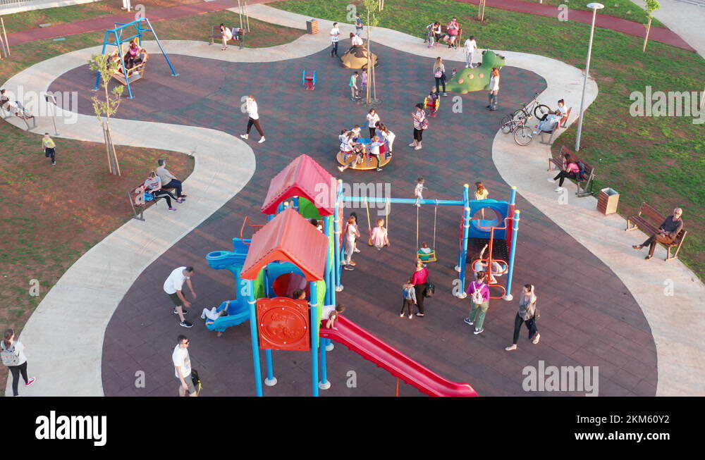 Playground for kids in a park, busy with excited and joyful children ...