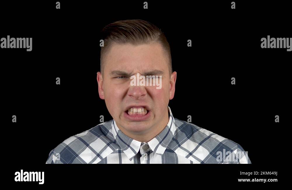 A young man takes off his mask and shows emotion on his face. Angry man ...