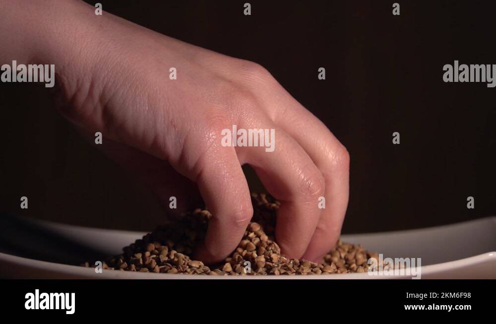 A woman Hands Pick Up A Handful Of Buckwheat Grains Hand Holding Grain ...