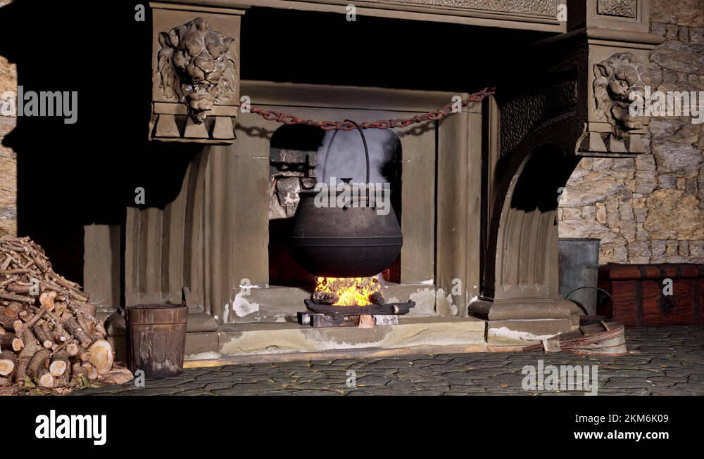 A large cooking pot hanging on a chain in the fireplace of a medieval ...