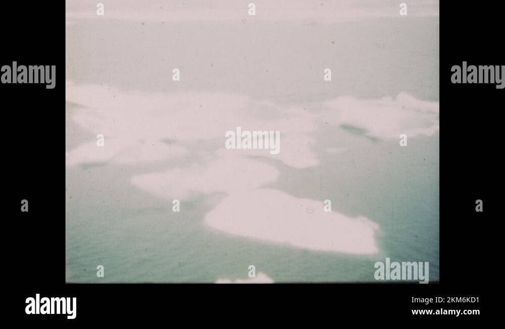 1940s: Ice floes on ocean. Man stand on side of ship railing. Man ...