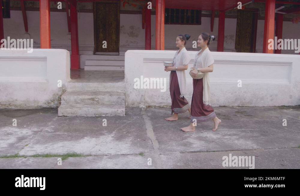 Two Girls In Thai Traditional Dress Walking Near Temple, Slow Motion ...