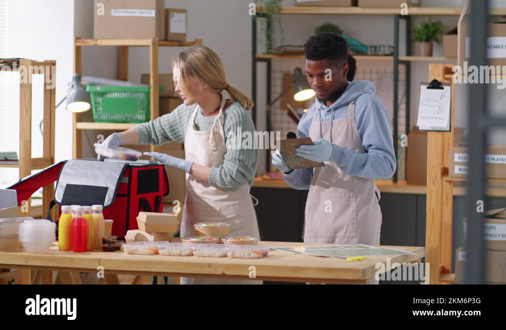 Multiethnic Coworkers Loading Food Delivery Bag with Meals Stock Video ...