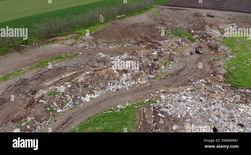 Abandoned Structures Next To A Garbage Hill On Landfill And Workers In ...