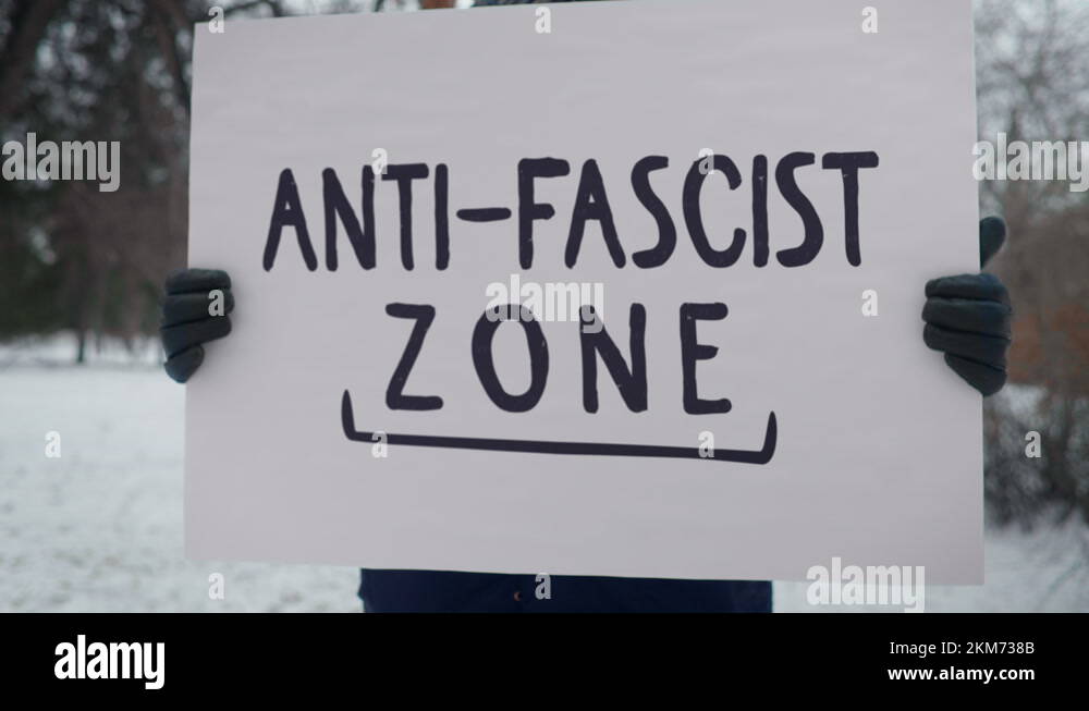 A person is holding a banner with Anti-Fascist Zone writing. Single ...