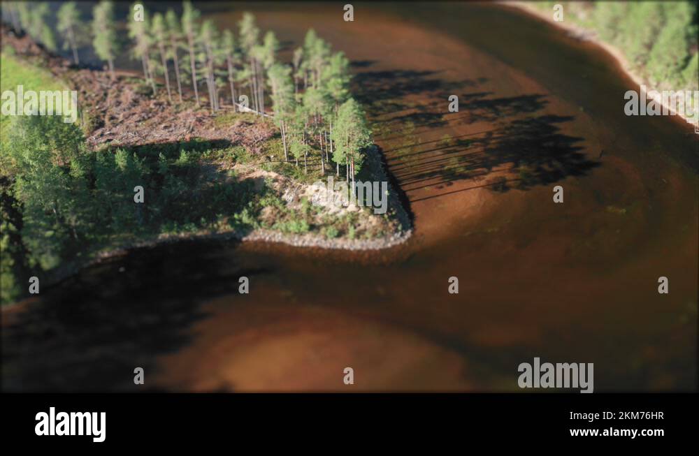 Sharp fir tree shadows reflecting on a still-alike surface of the Otra ...