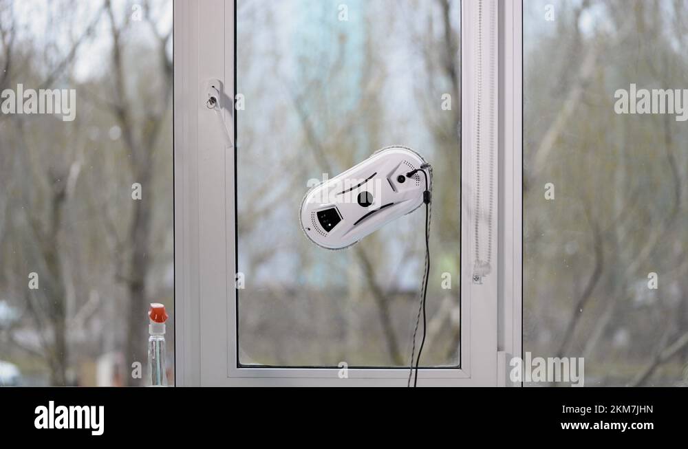 Cleaning robot at work at home. The robot cleans the mirror in the ...