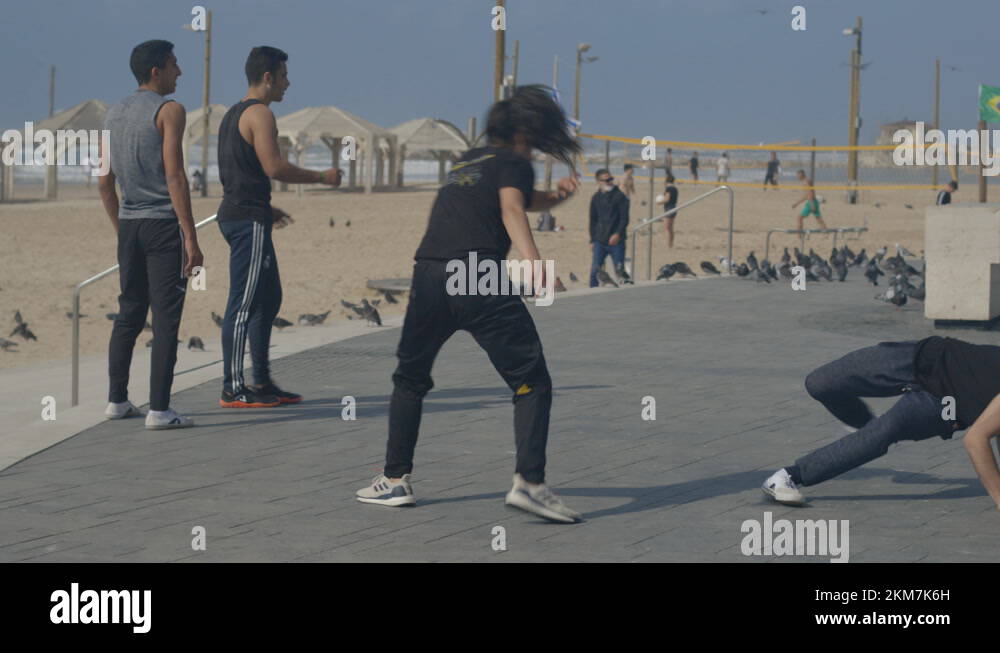 Capoeira workout at the beach promenade. Young Israeli male and female ...
