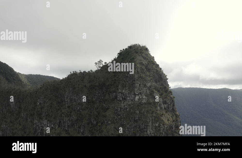 4K drone shot slowly orbiting a mountain cliff at Border Ranges ...