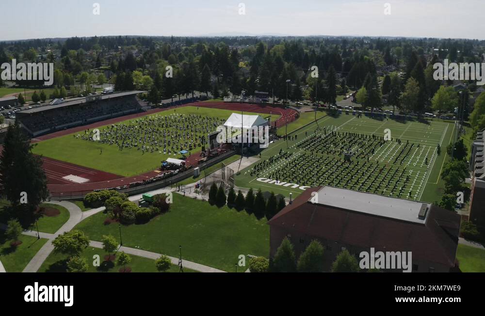 Students With Family On An Open Field During Graduation Ceremony Amidst ...