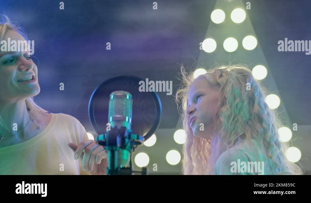 Mom And Daughter Are Engaged In Singing Into Microphone In Karaoke Club