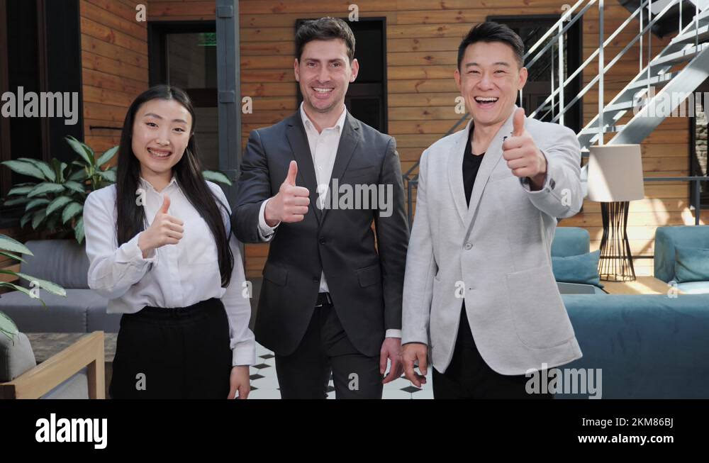Three multinational asian business people showing thumb up Winner ...