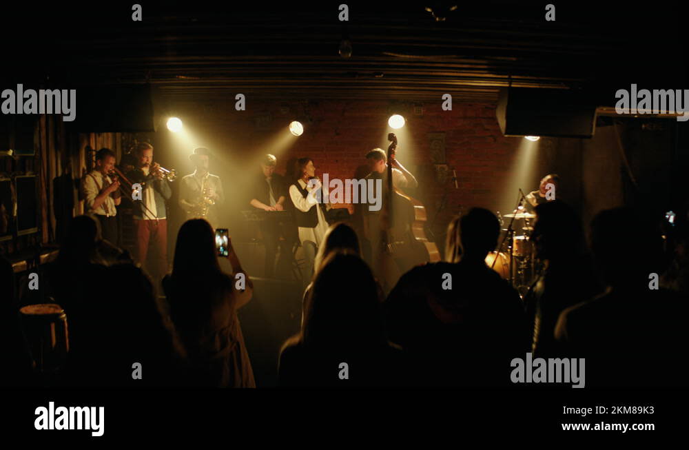 WIDE People dancing during concert of a modern jazz band playing on a ...