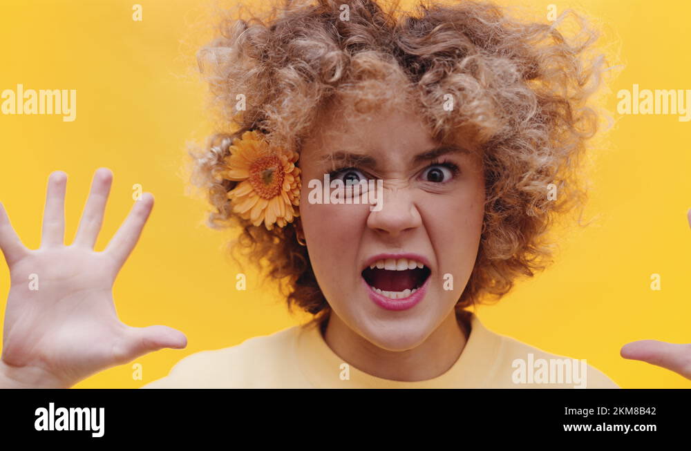 Young angry woman freaking out and making a funny angry face expression ...