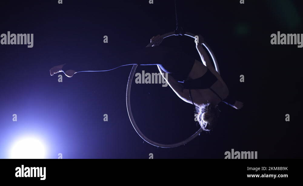 Girl gymnast hanging on the acrobatic ring making performance show ...
