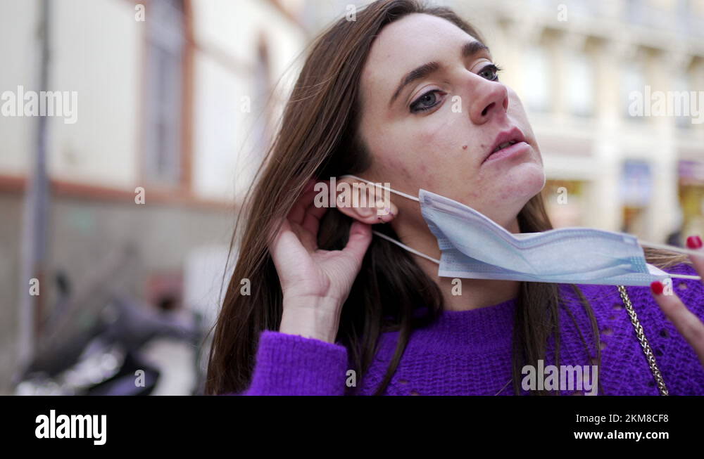Young woman putting covid-19 face mask. Person wearing surgicak mask ...