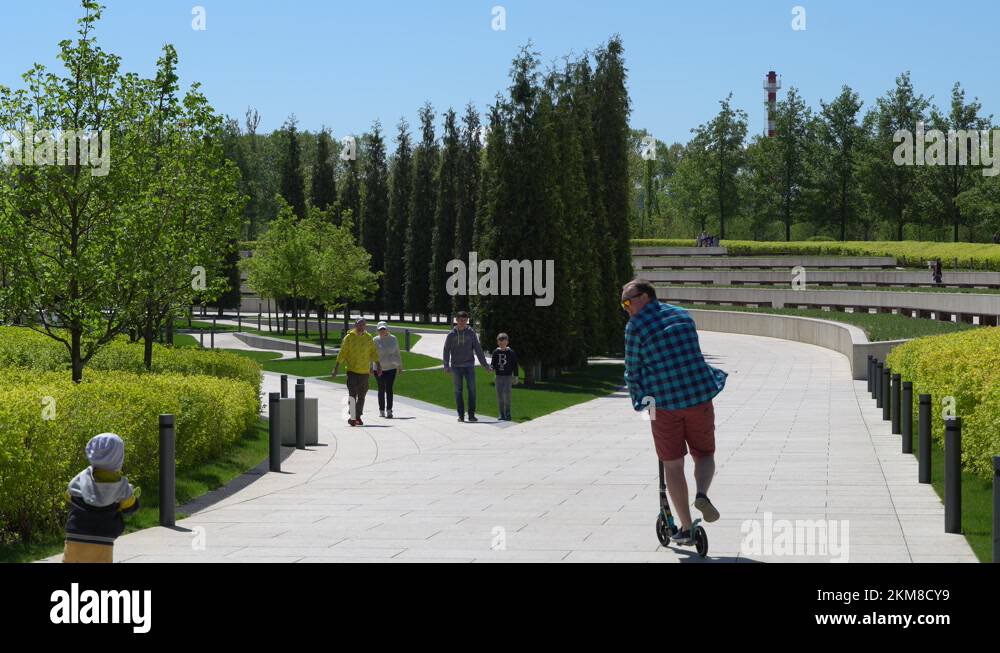 People walk and ride scooters along paths between terraces in Public ...